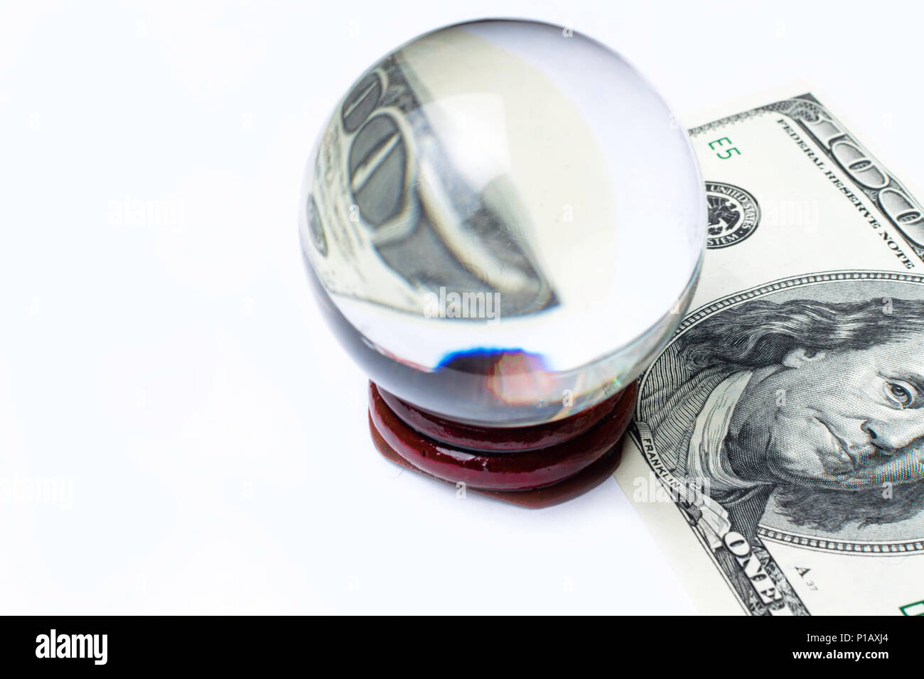 Hundred dollar bill under a magnifying glass ball is being inspected ...