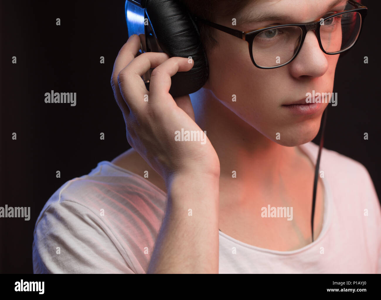 closeup cropped photo of young music producer in headphones and glasses ...