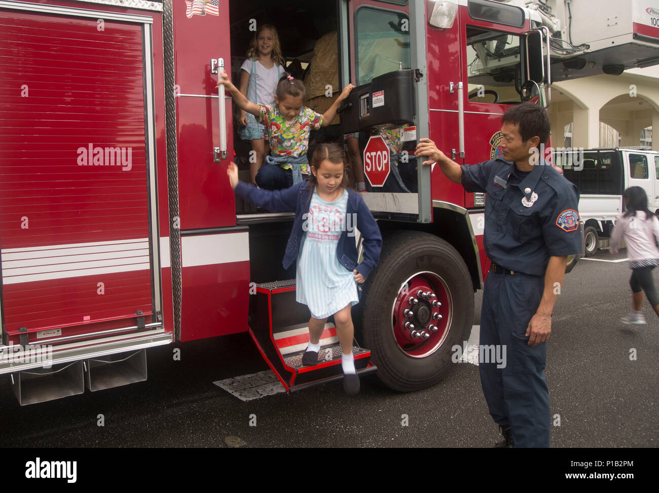 Harayuki Shinzato, right, helps students exit a fire engine at E.C ...