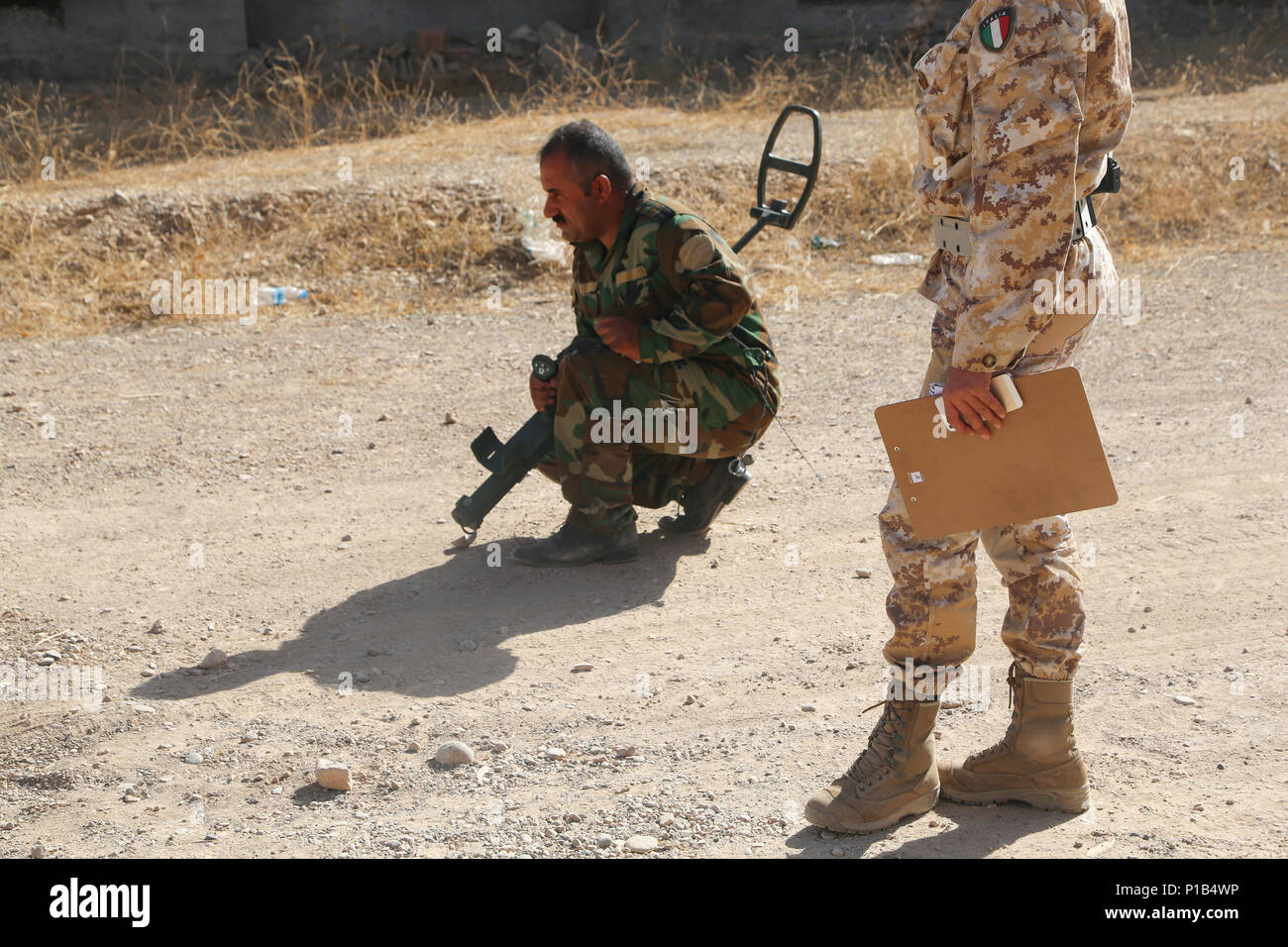 An Italian trainer observes a Peshmerga solider looking for an ...