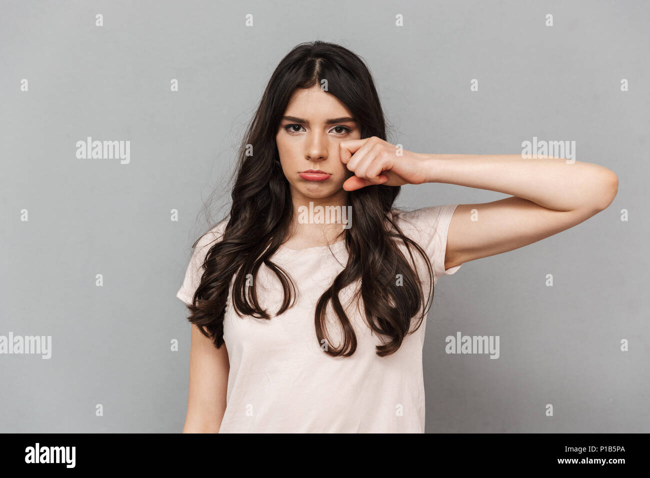 Image of displeased sad young lady standing isolated over grey ...