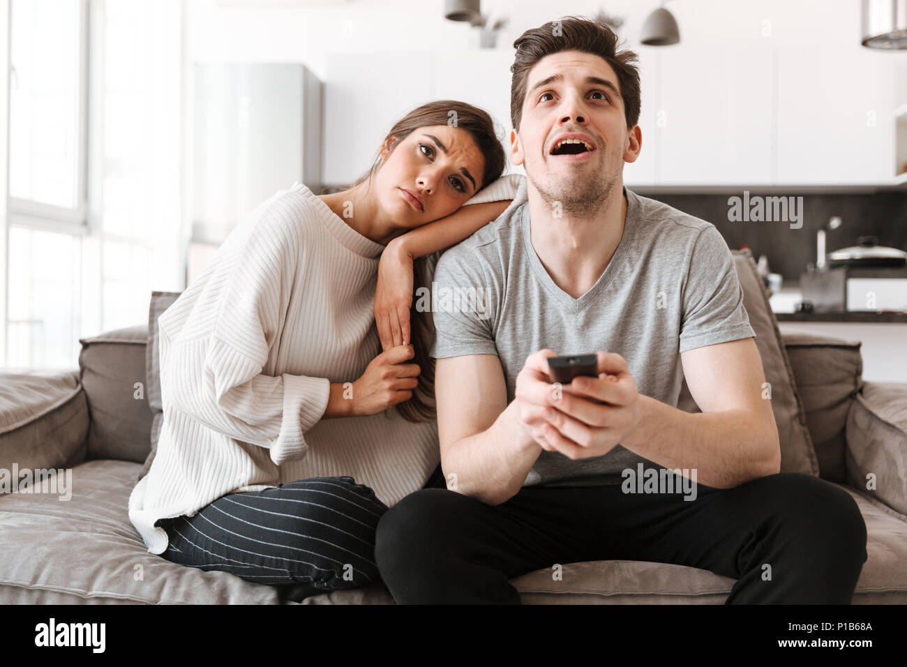 Portrait of a disappointed young woman sitting with her boyfriend on a ...