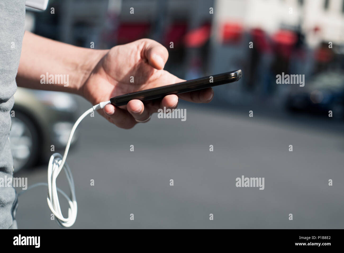 closeup of a young caucasian man outdoors using a smpartphone with a ...