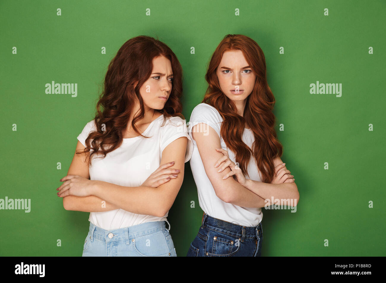 Two arguing women 20s with ginger hair in casual wear standing back to ...