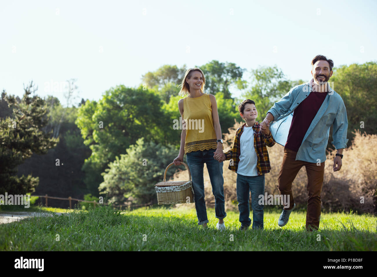 Content family having a walk in the park Stock Photo - Alamy