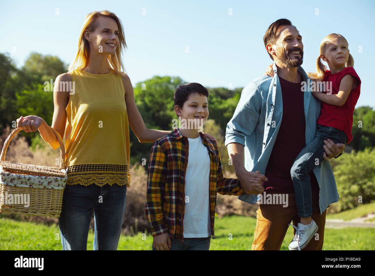Cheerful family having a walk in the park Stock Photo - Alamy