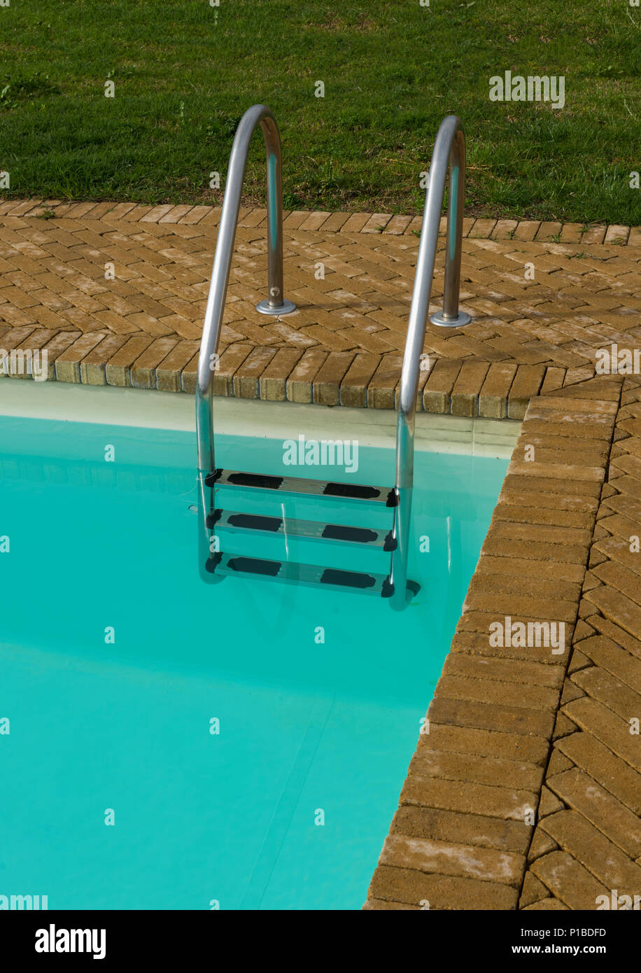 swimming pool with stairs and grass field Stock Photo - Alamy
