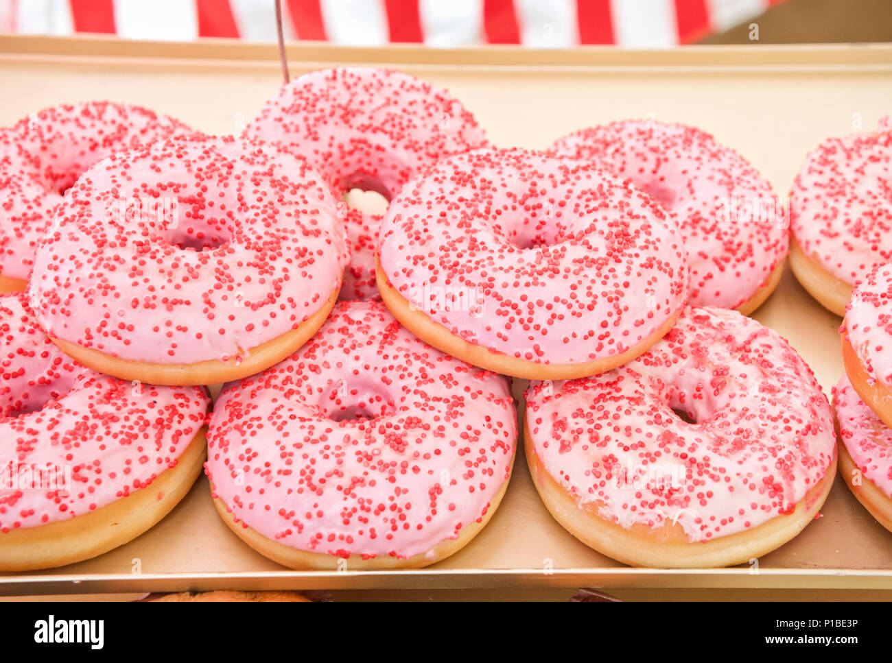 Pink donuts with sprinkles on a tray Stock Photo - Alamy