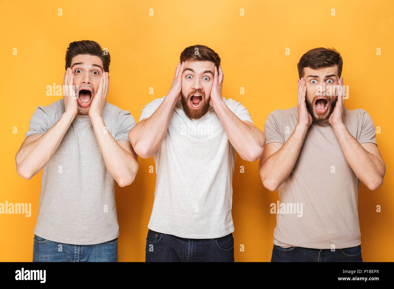 Three young shocked men screaming isolated over yellow background Stock ...