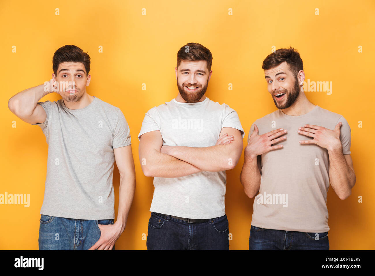 Three young confused men looking at camera isolated over yellow ...