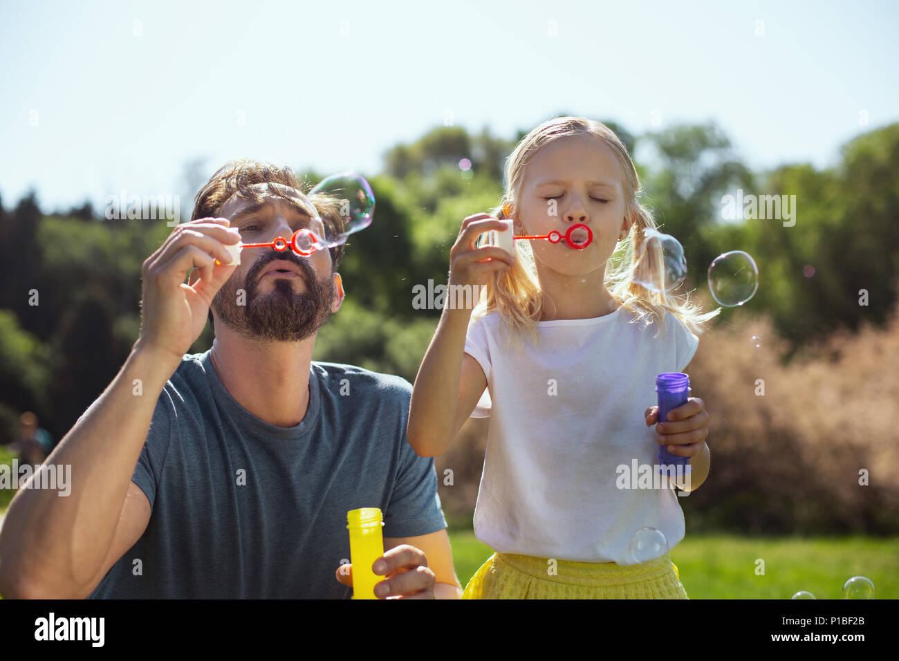 Inspired father blowing bubbles with his daughter Stock Photo - Alamy