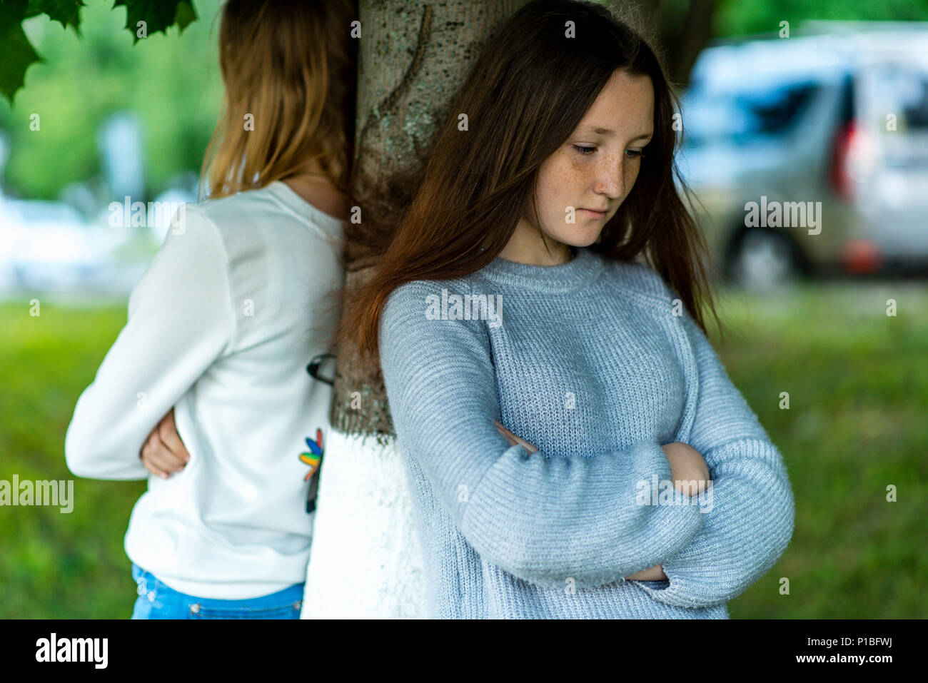 Two girlfriends in the summer in a park in nature. Offended each other ...