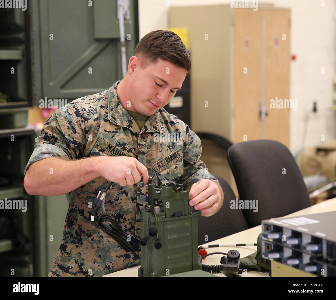 Lance Cpl. Thomas Mauro works on a radio in his work section aboard ...