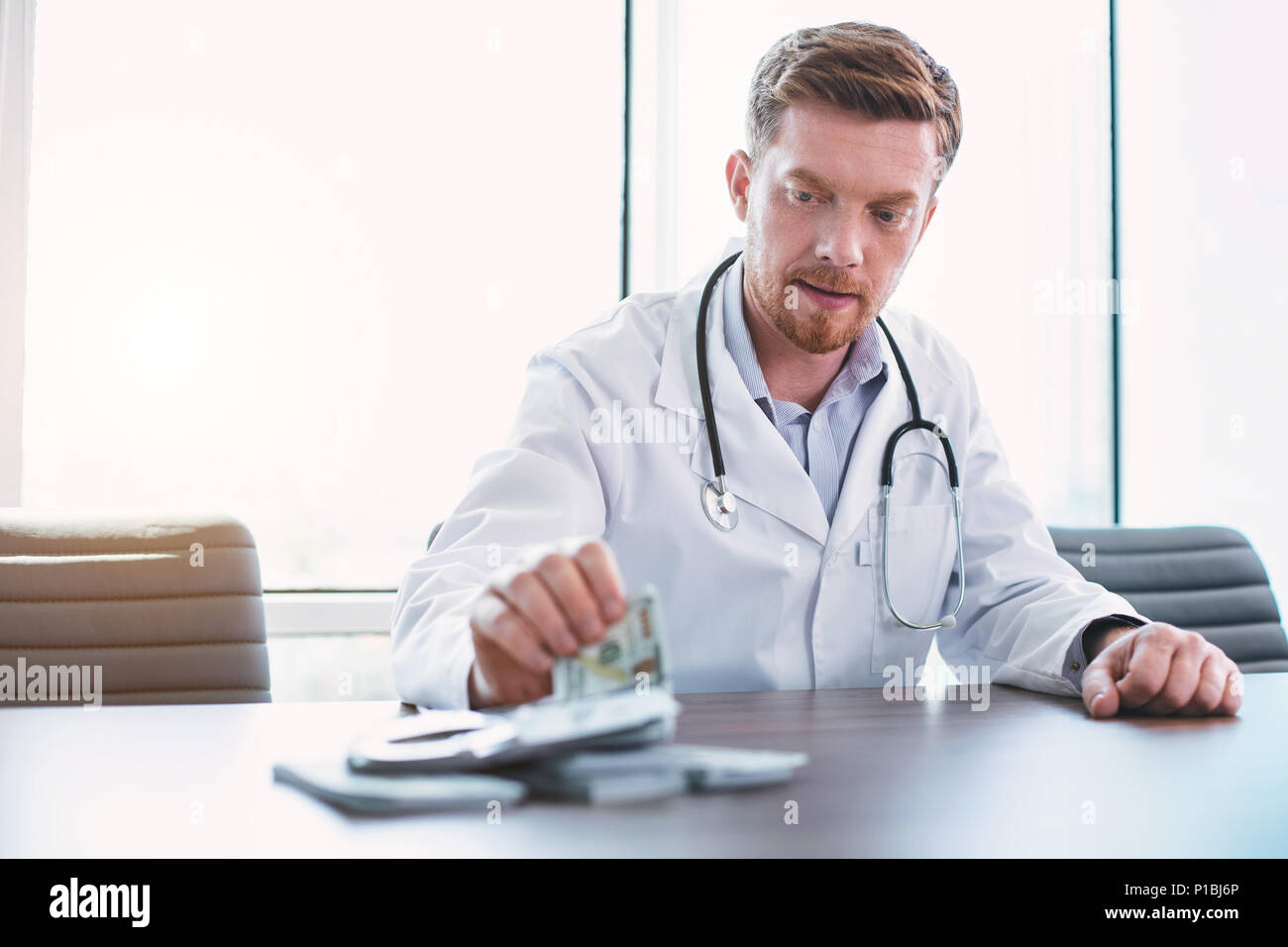 Experienced doctor taking bribes in his office Stock Photo - Alamy