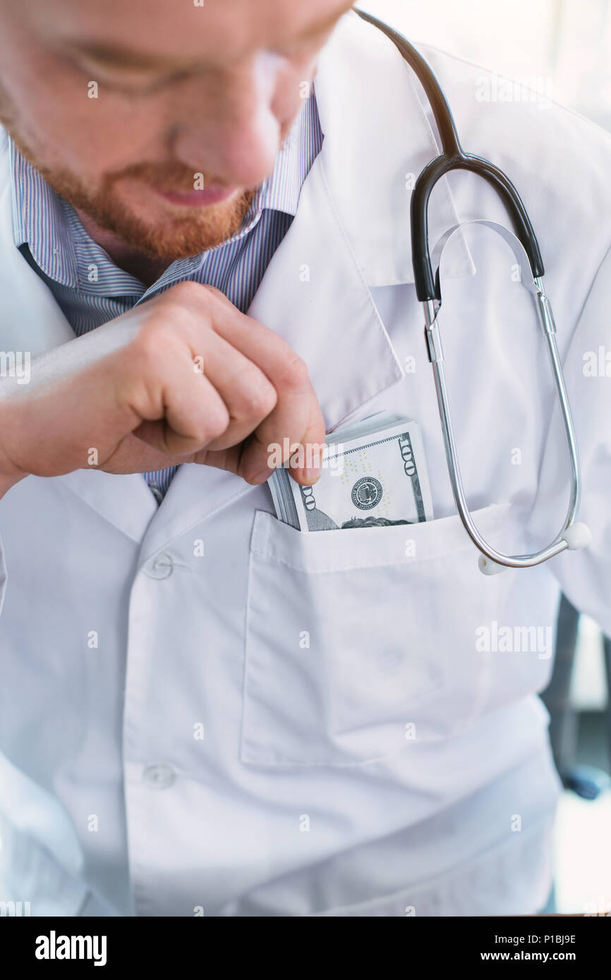 Glad doctor taking bribes in his office Stock Photo - Alamy