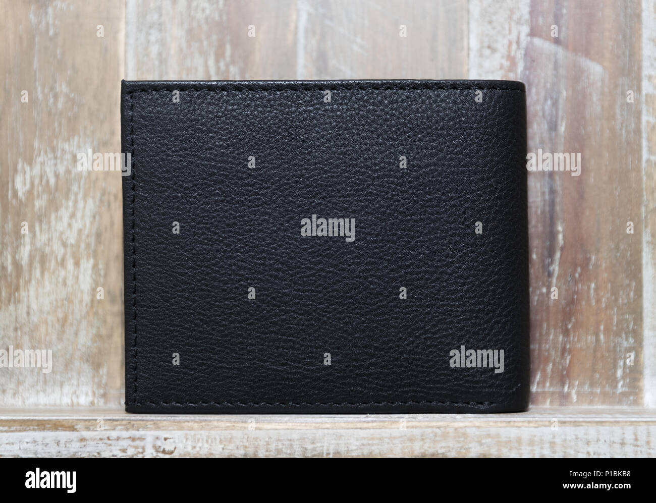 Black wallet . Isolated wooden background Stock Photo - Alamy