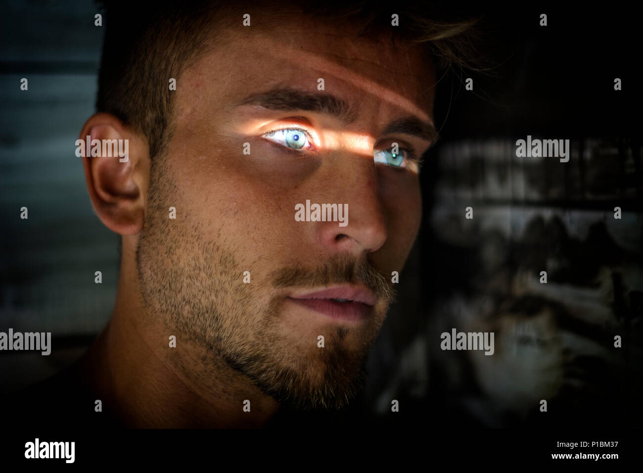 Slit of light illuminating man's blue eyes Stock Photo - Alamy