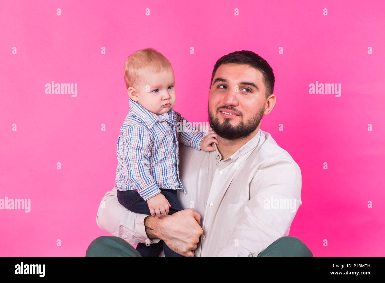 happy father with a baby son isolated on a pink background Stock Photo ...