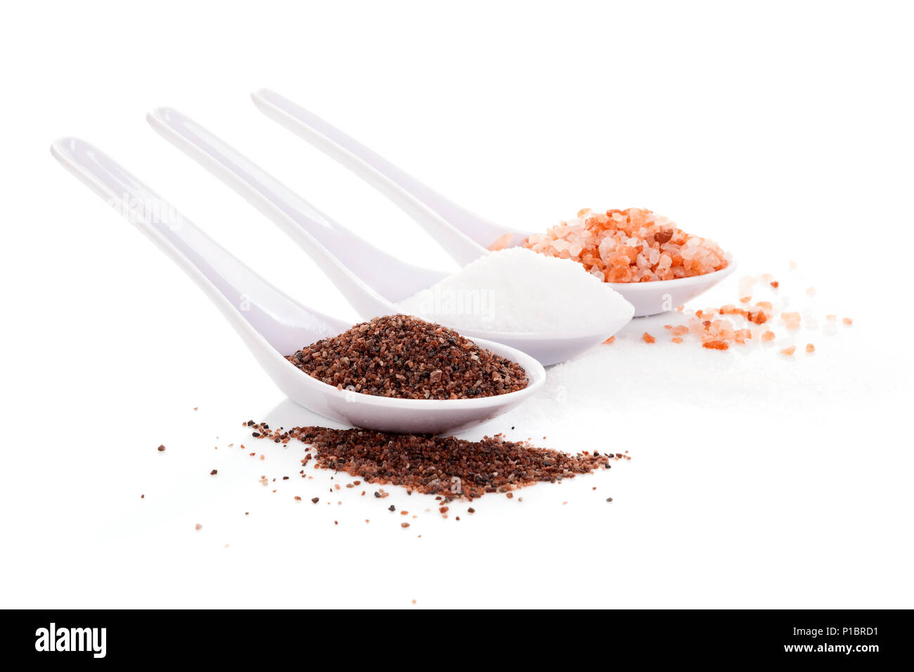 Various types of organic salt in spoons. Isolated on white background ...