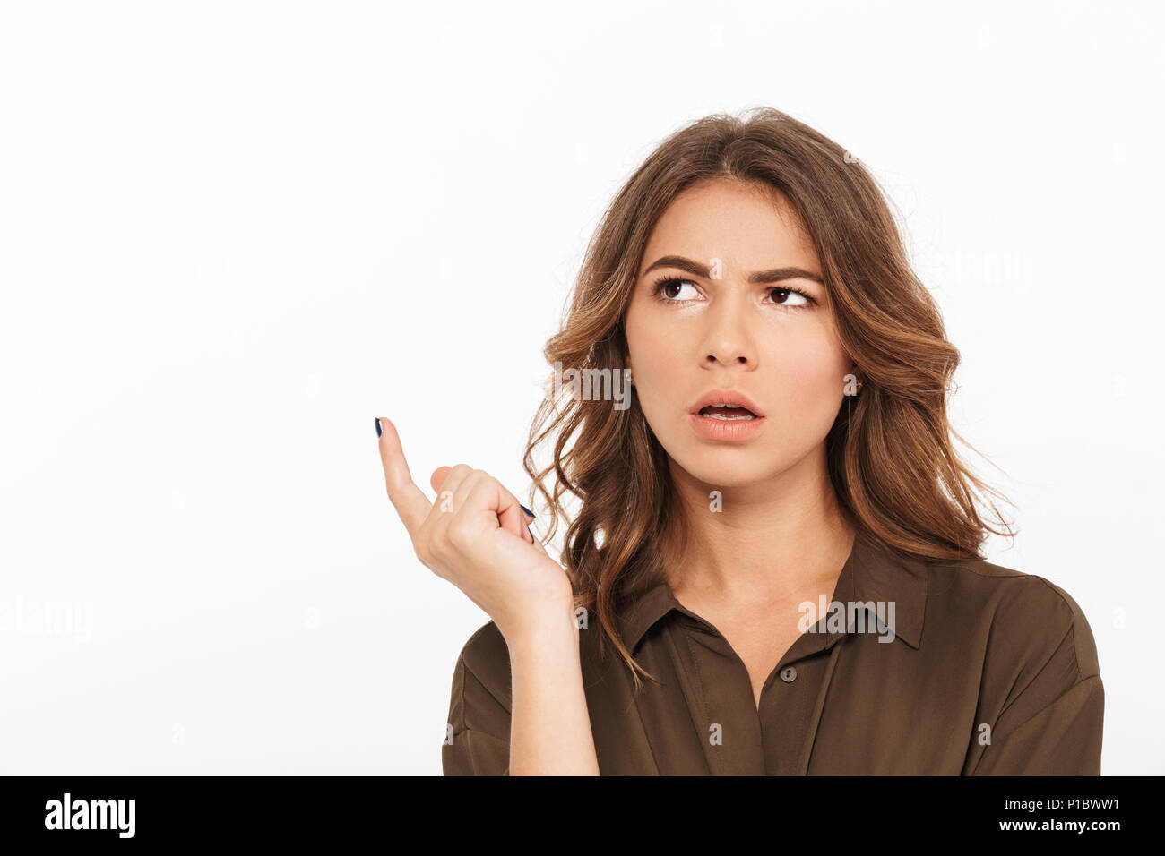 Portrait of a confused young woman looking away at copy space isolated ...