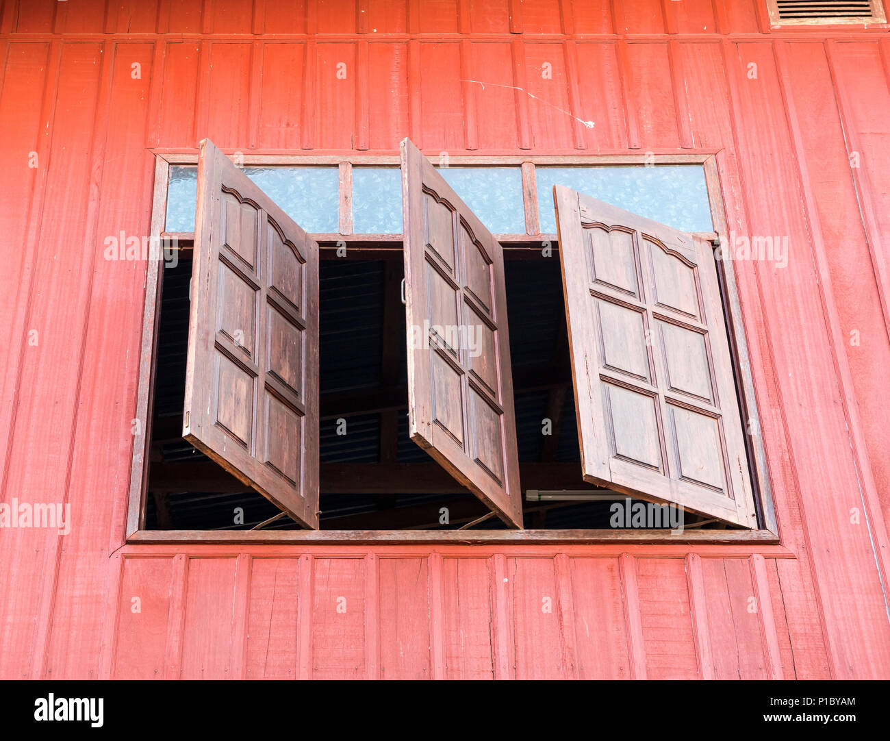 Wooden window is opened from the second floor of the countryside house ...
