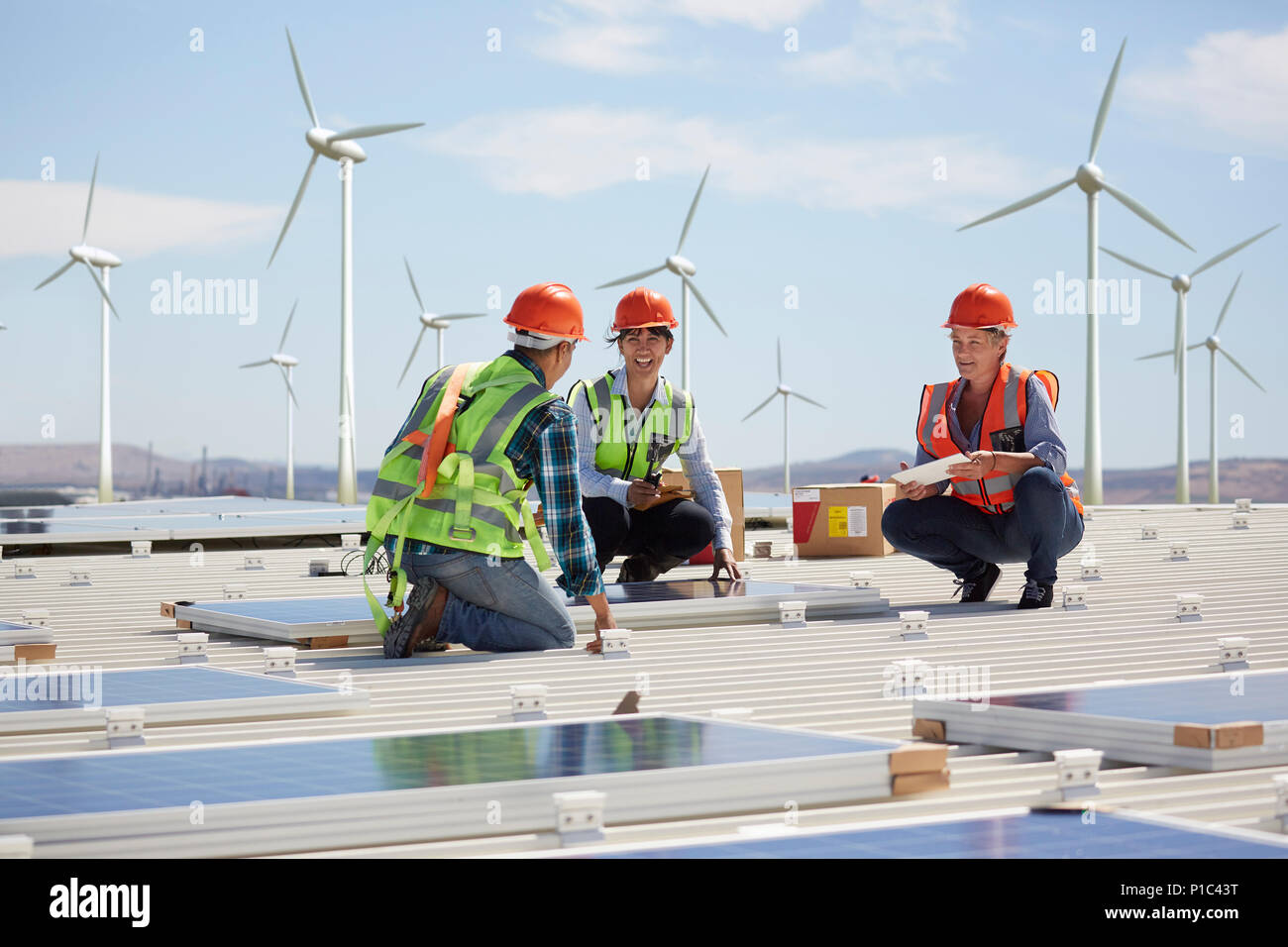 Engineers installing solar panels at alternative energy power plant ...