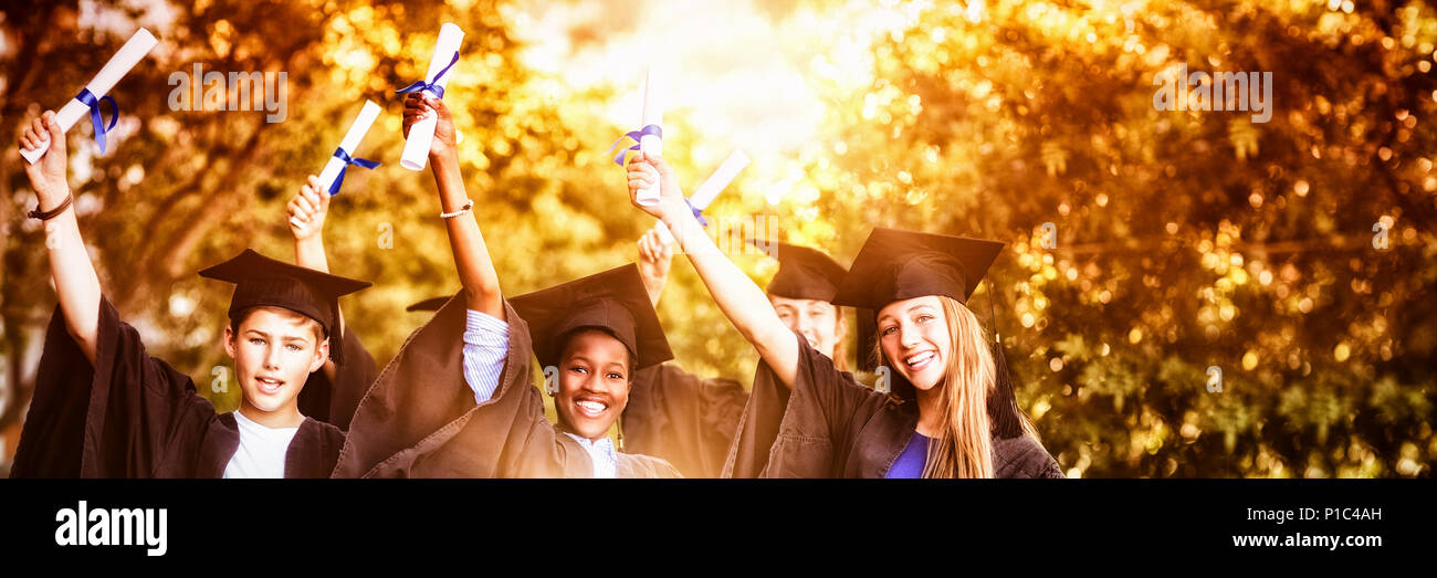 Portrait of graduate school kids standing with degree scroll in campus ...