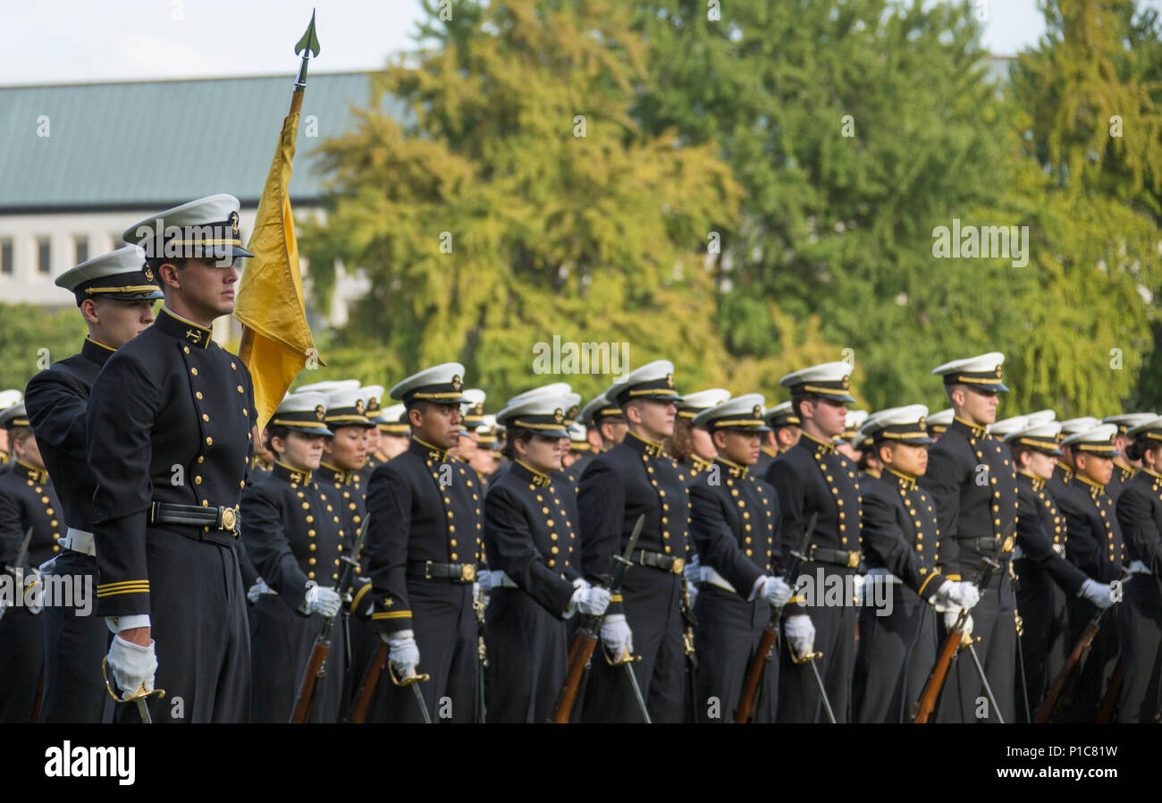 Midshipmen with the U.S. Naval Academy (USNA) stand at parade rest ...
