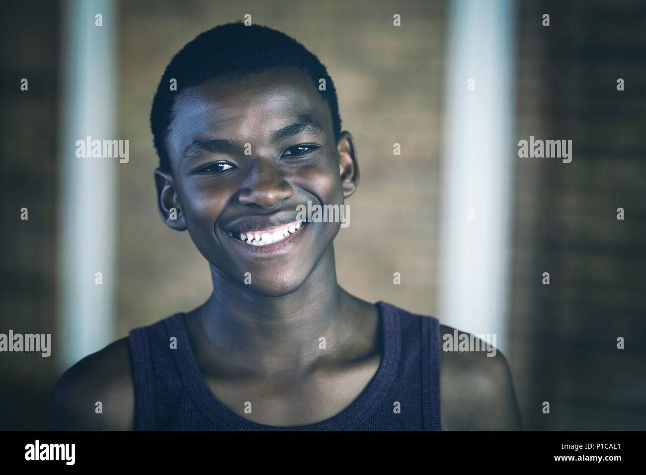 Smiling high school boy standing in the sports court Stock Photo - Alamy