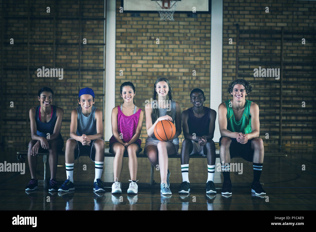 High school kids sitting on a bench in basketball court Stock Photo - Alamy
