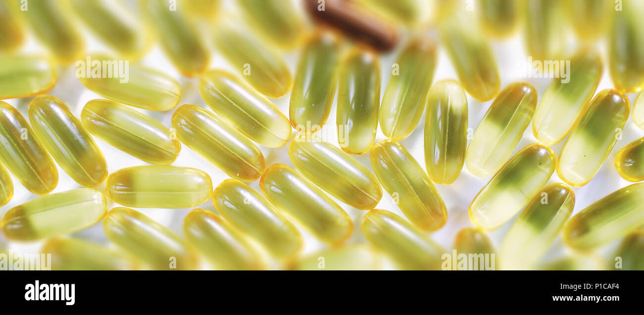 Medical medicines and supplements transparent capsules of yellow color ...