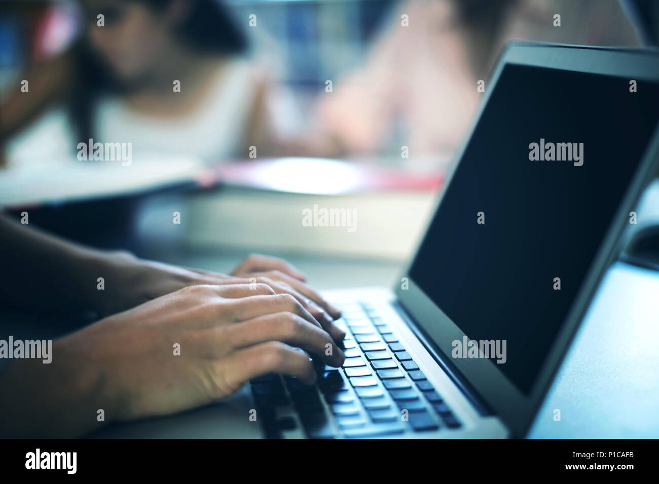 Student using laptop in library Stock Photo - Alamy