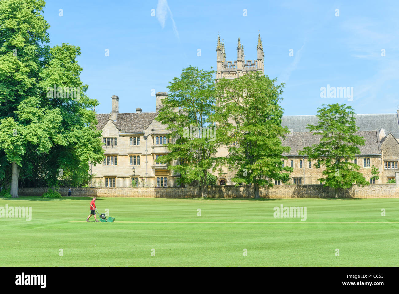 A groundsman mows the cricket pitch on the playing field (known as ...