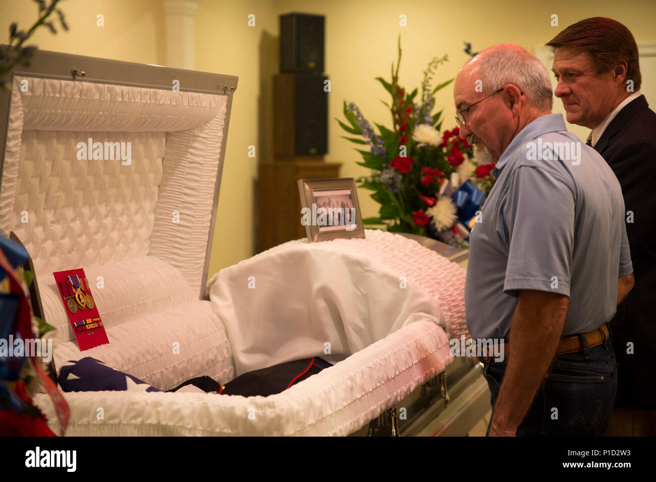 Lane Boler and Ronnie Taylor, view the casket holding the physical remains, uniform, and photo ...