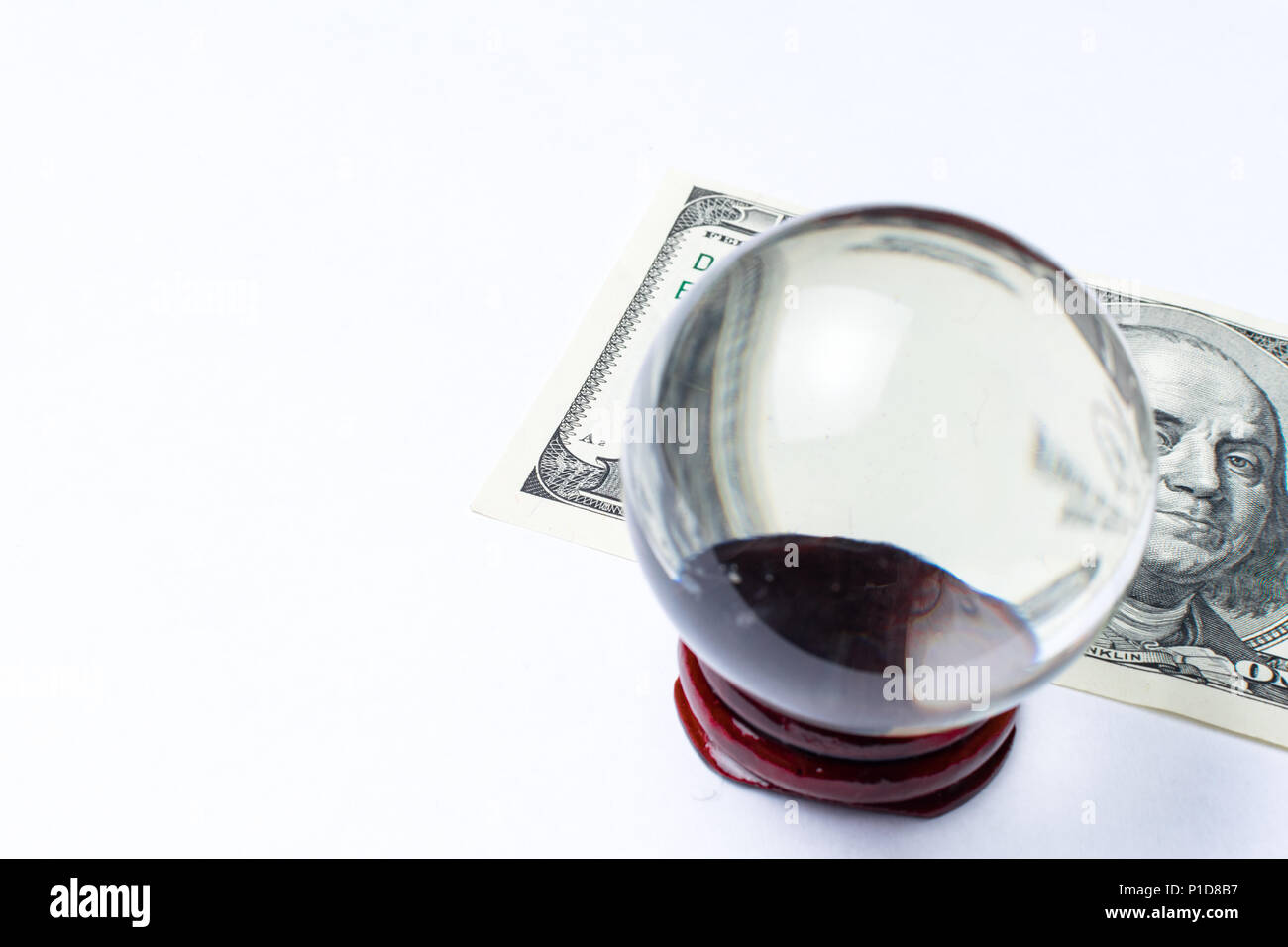 Hundred dollar bill under a magnifying glass ball is being inspected ...