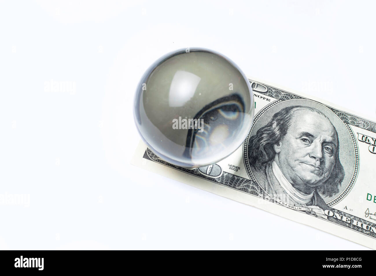 Hundred dollar bill under a magnifying glass ball is being inspected ...