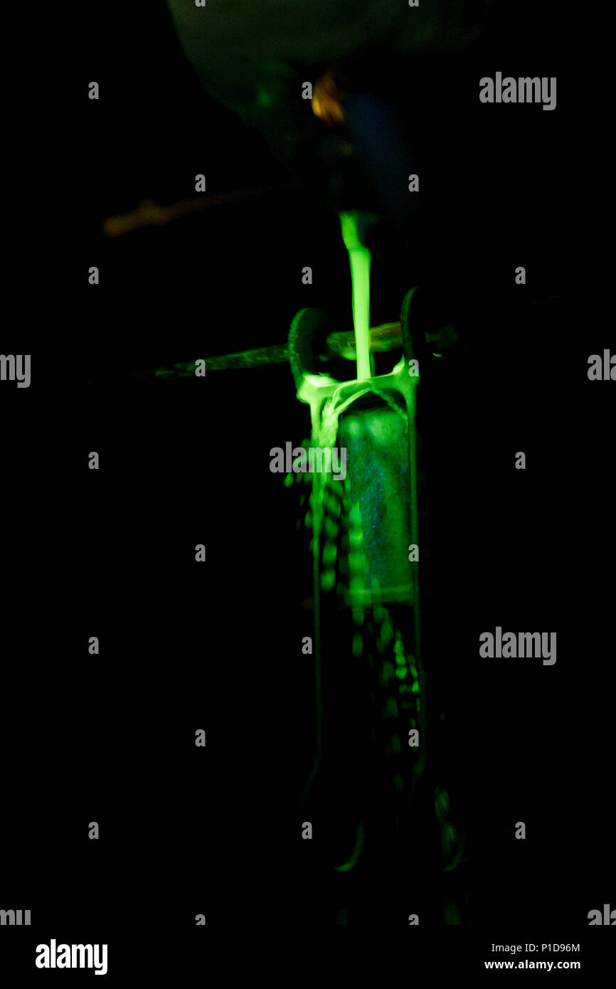 A magnetic particle bath fluoresces under ultraviolet light during a ...