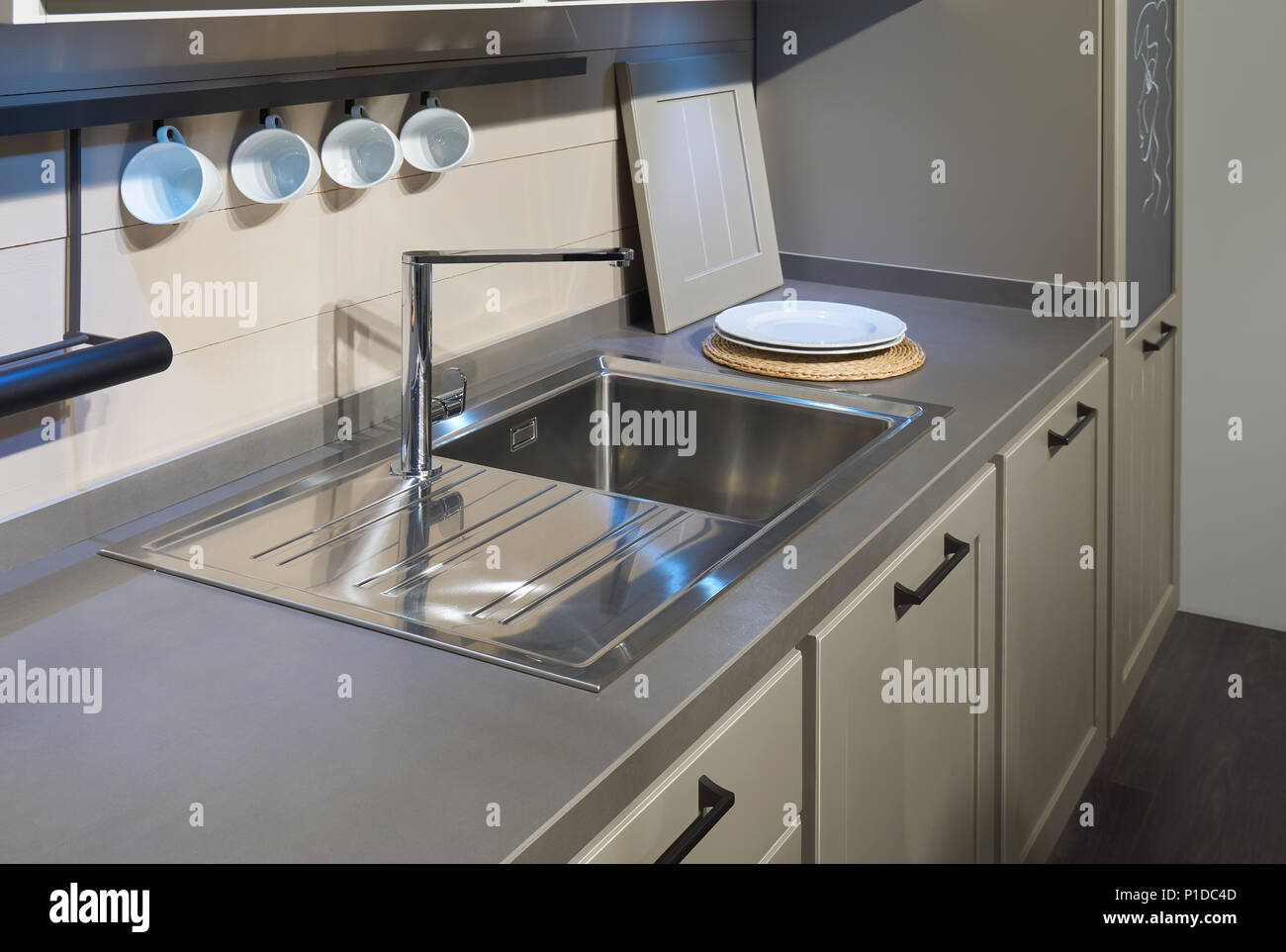 Modern kitchen furniture, stainless still sink, metal mixer and some ...