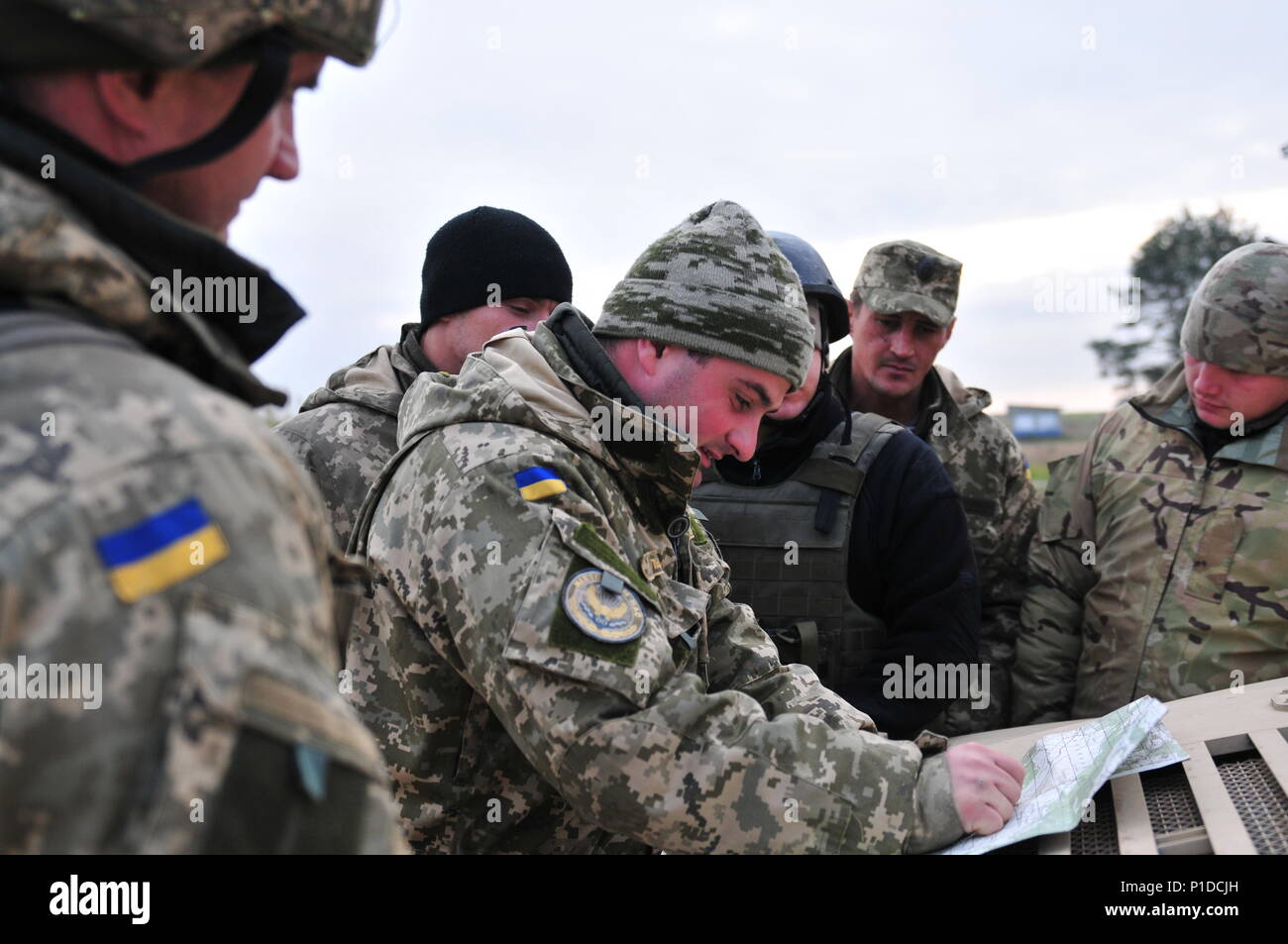 A Ukrainian instructor explains the gunnery exercise to Soldiers from ...