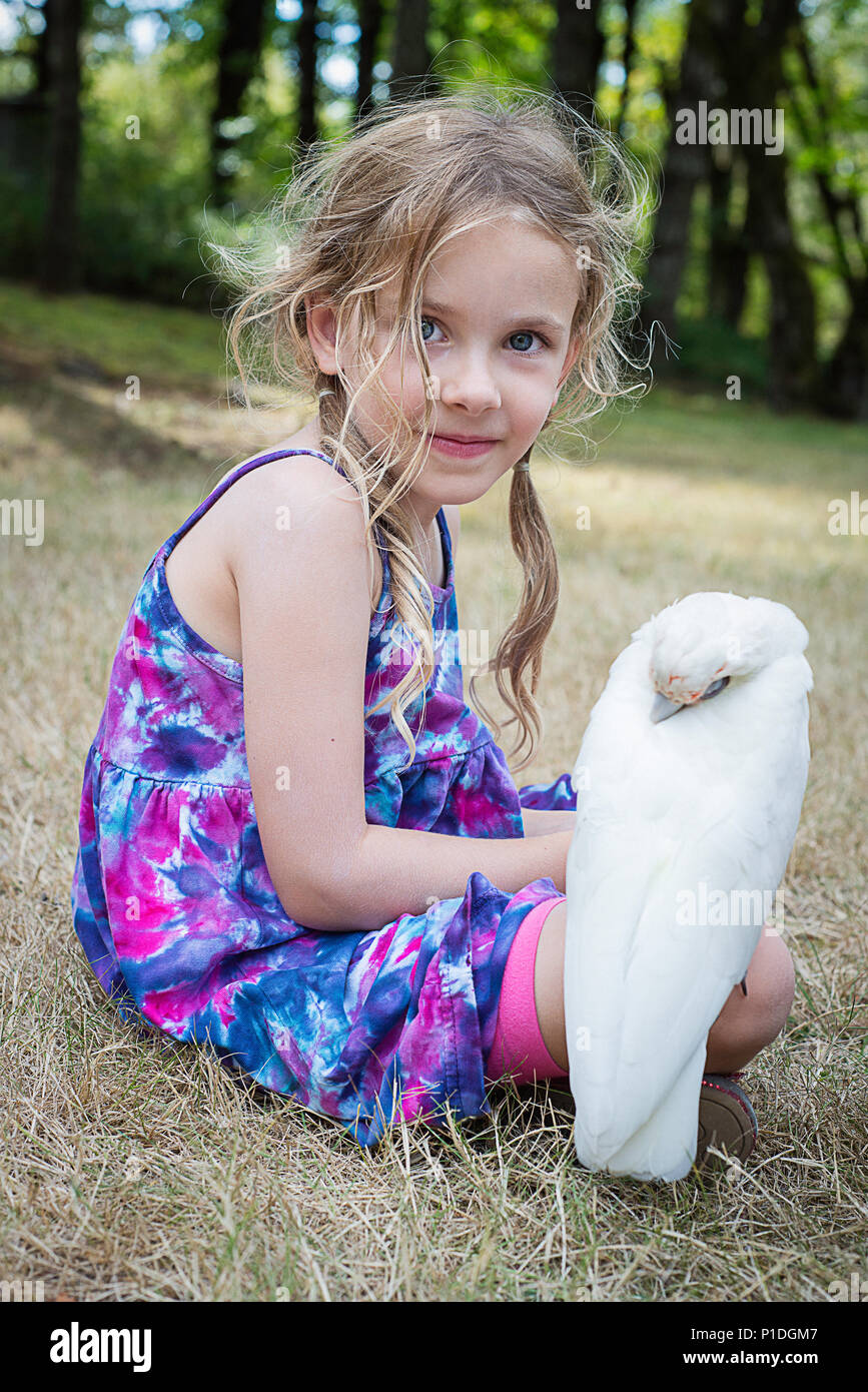 A young girl and a bare eyed cockatoo Stock Photo - Alamy