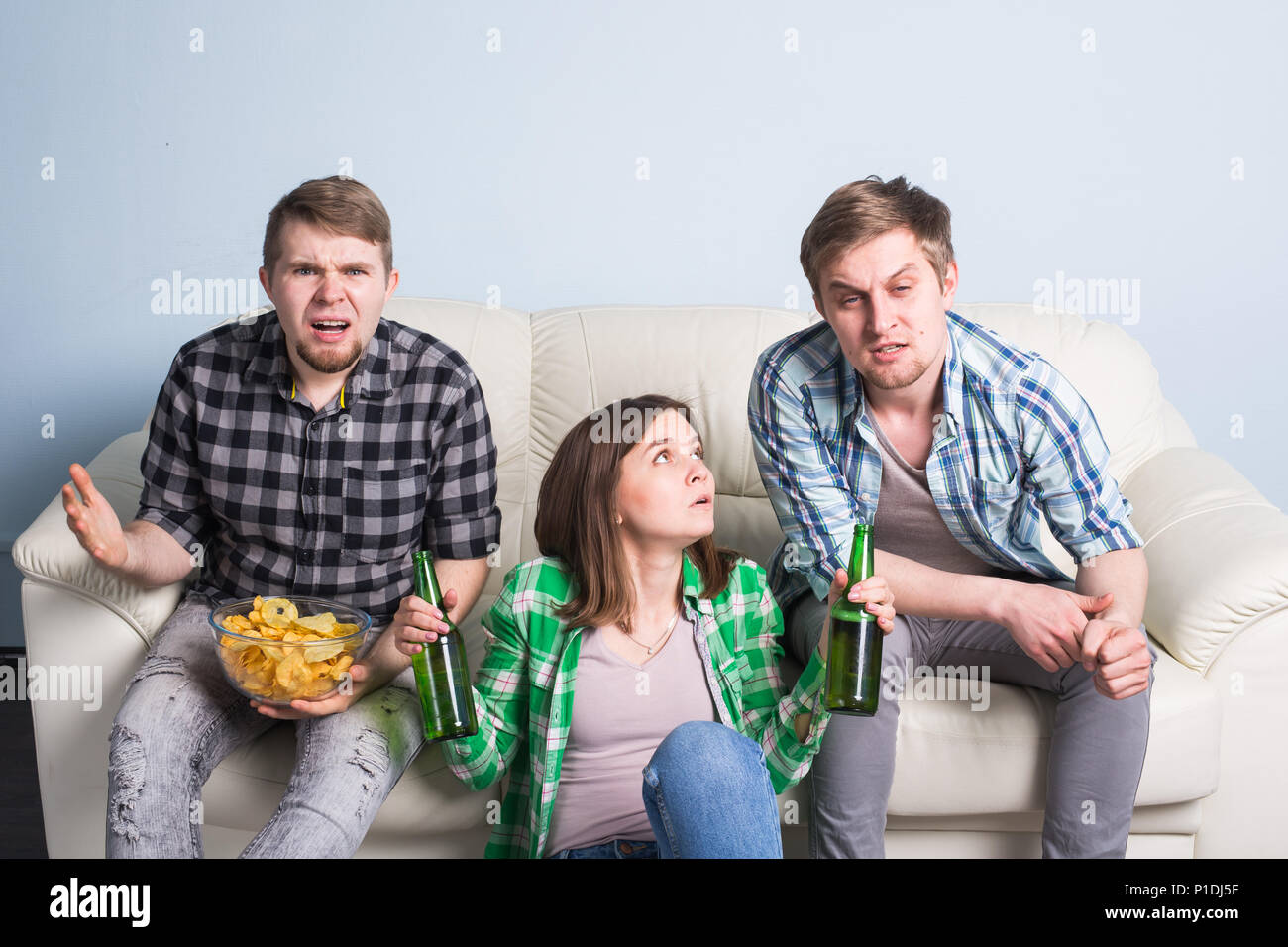 Young men drink beer, eat pizza and cheering for football Stock Photo ...