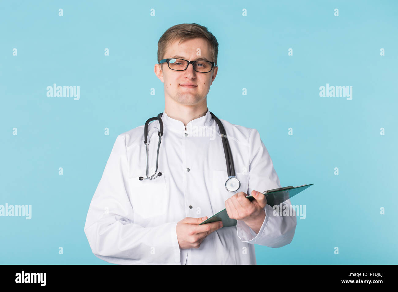 Medical doctor writing prescription over blue background with copyspace ...
