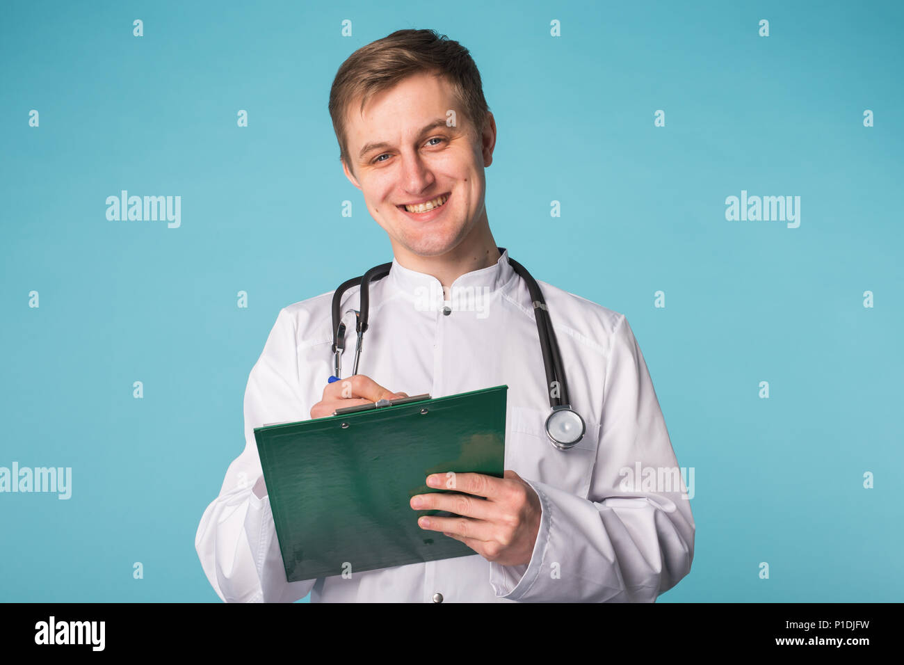 Medical doctor writing prescription over blue background with copyspace ...