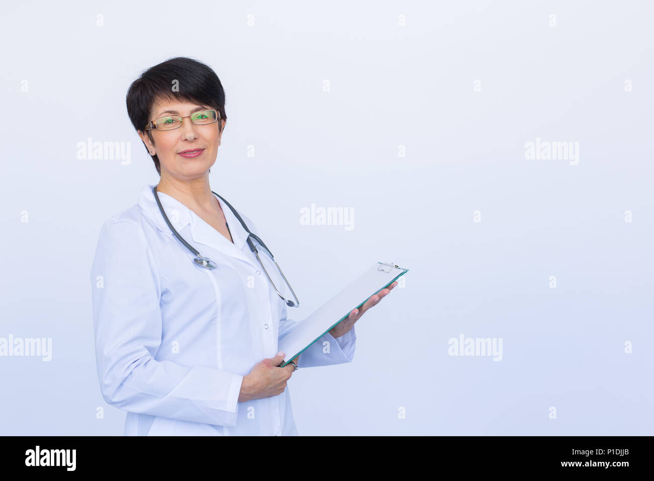 Medical doctor writing prescription over white background with ...