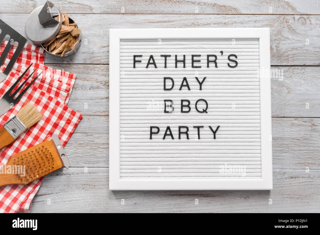 Father's Day BBQ Party sign on a white memo board with cooking tools ...