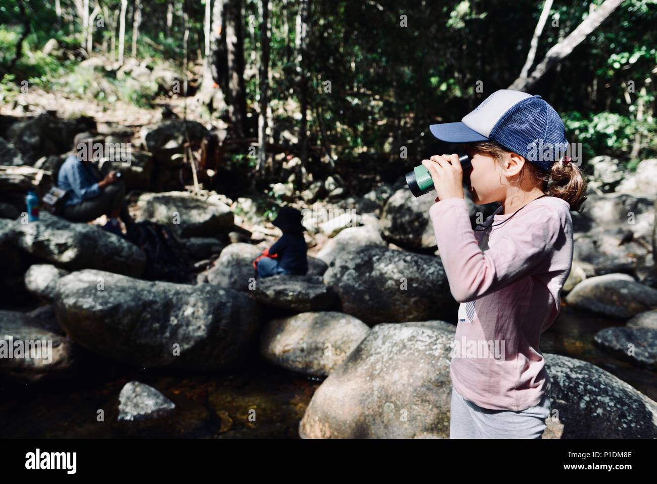 Children sitting on rocks in Rollingstone creek, Paluma Range National ...