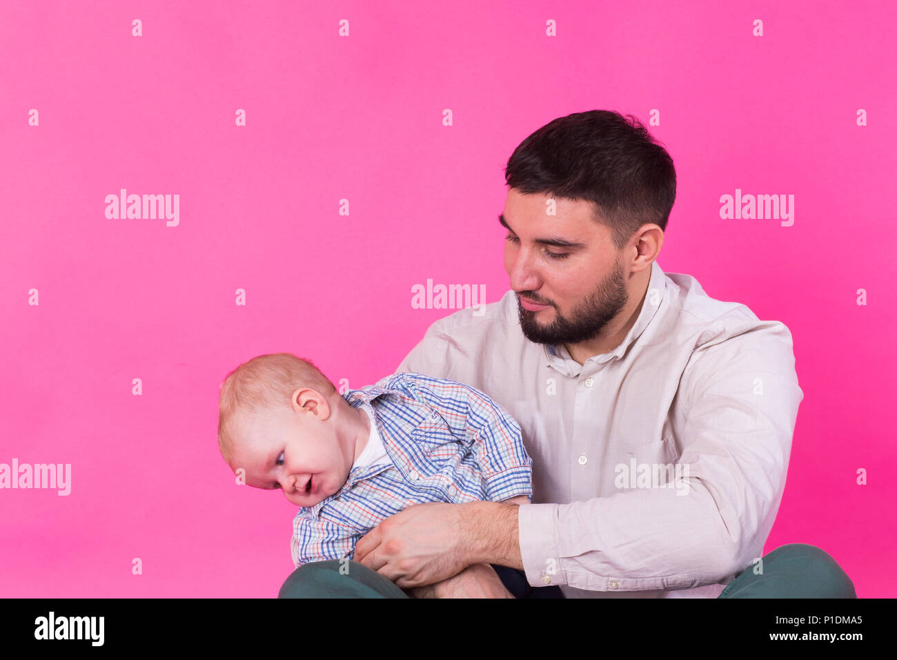 happy father with a baby son isolated on a pink background Stock Photo ...