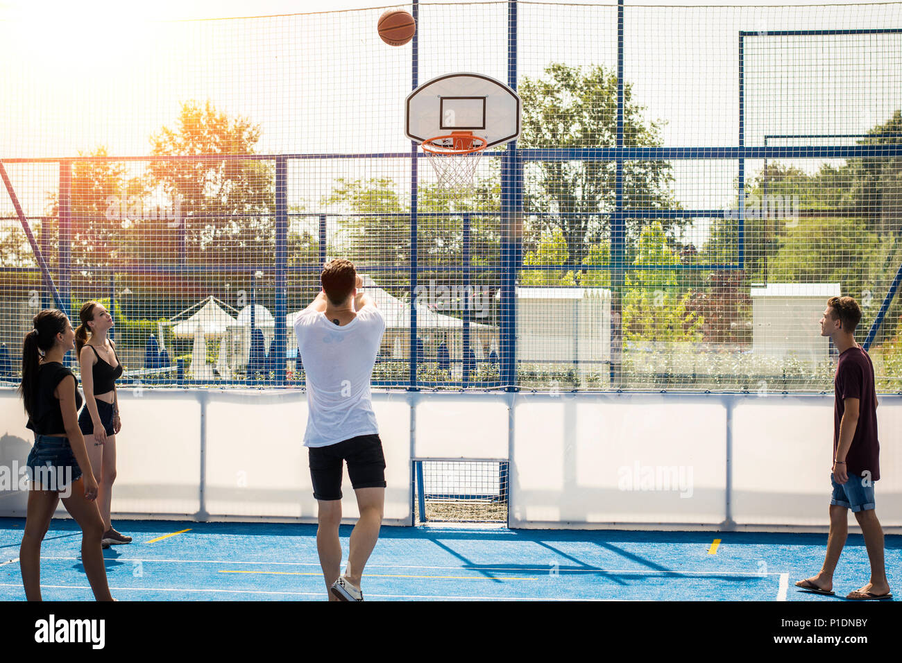 Young people playing basketball on playground Stock Photo - Alamy