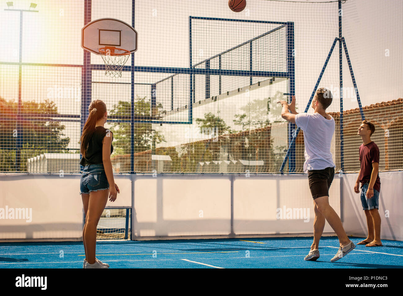 Young people playing basketball on playground Stock Photo - Alamy