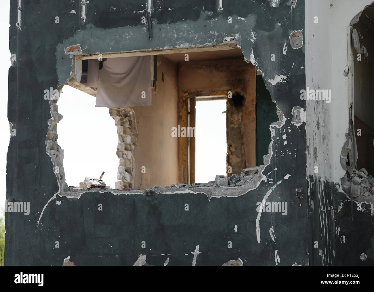 completely destroyed house with a big hole in the wall of the room ...